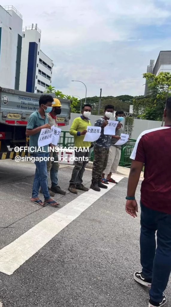 9 Men Stand Outside AMK Building Holding Signs Demanding Salaries ...
