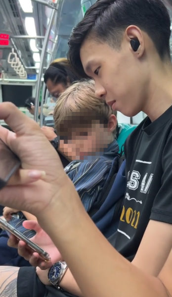 S'pore Man Notices Boy Peeping At Screen On MRT, Tilts Phone To Let Him See