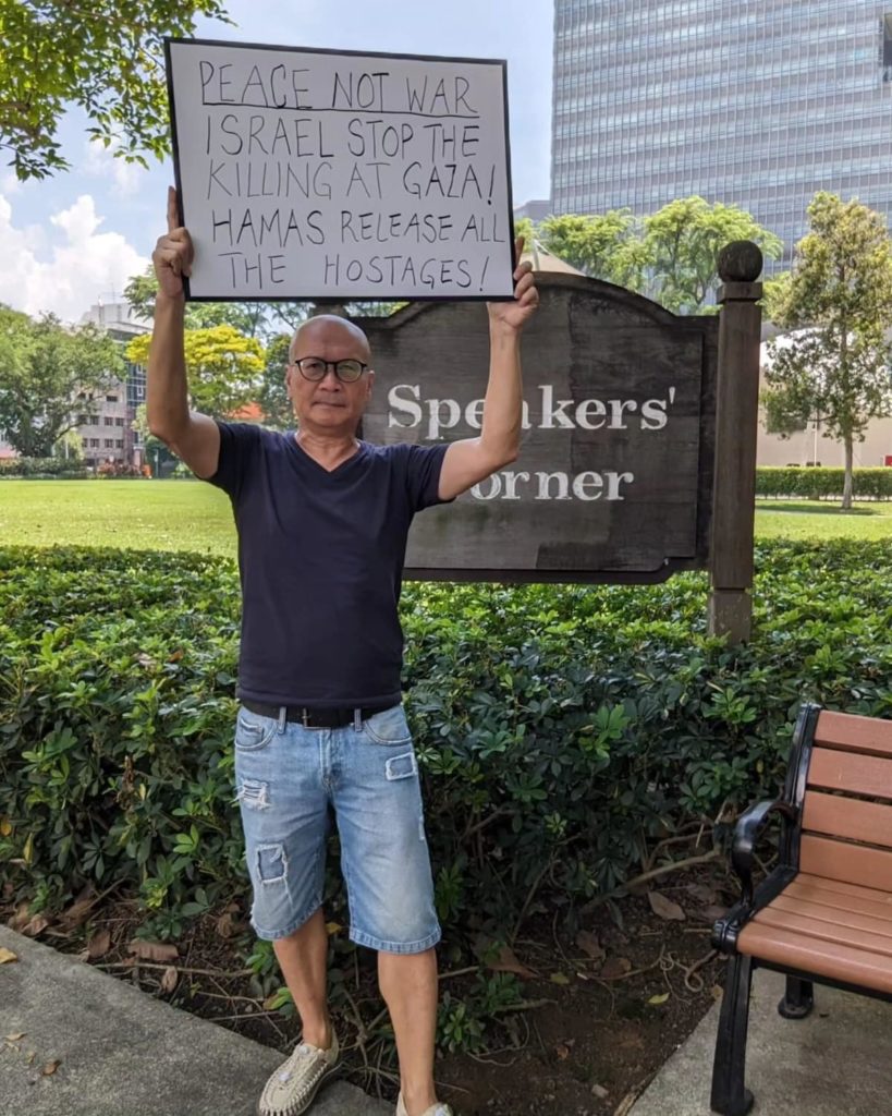 Activist Gilbert Goh Holds Sign About Israel-Hamas Conflict At Speakers ...