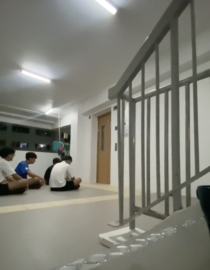 Youths sit in front of HDB lift to wait for food delivery, shake hands ...