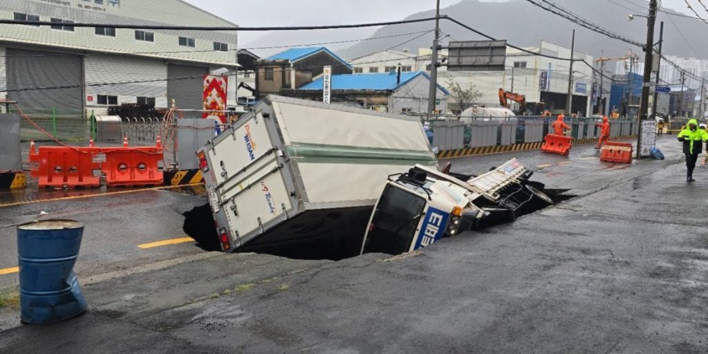2 trucks fall into 8-metre deep sinkhole after road collapses due to ...
