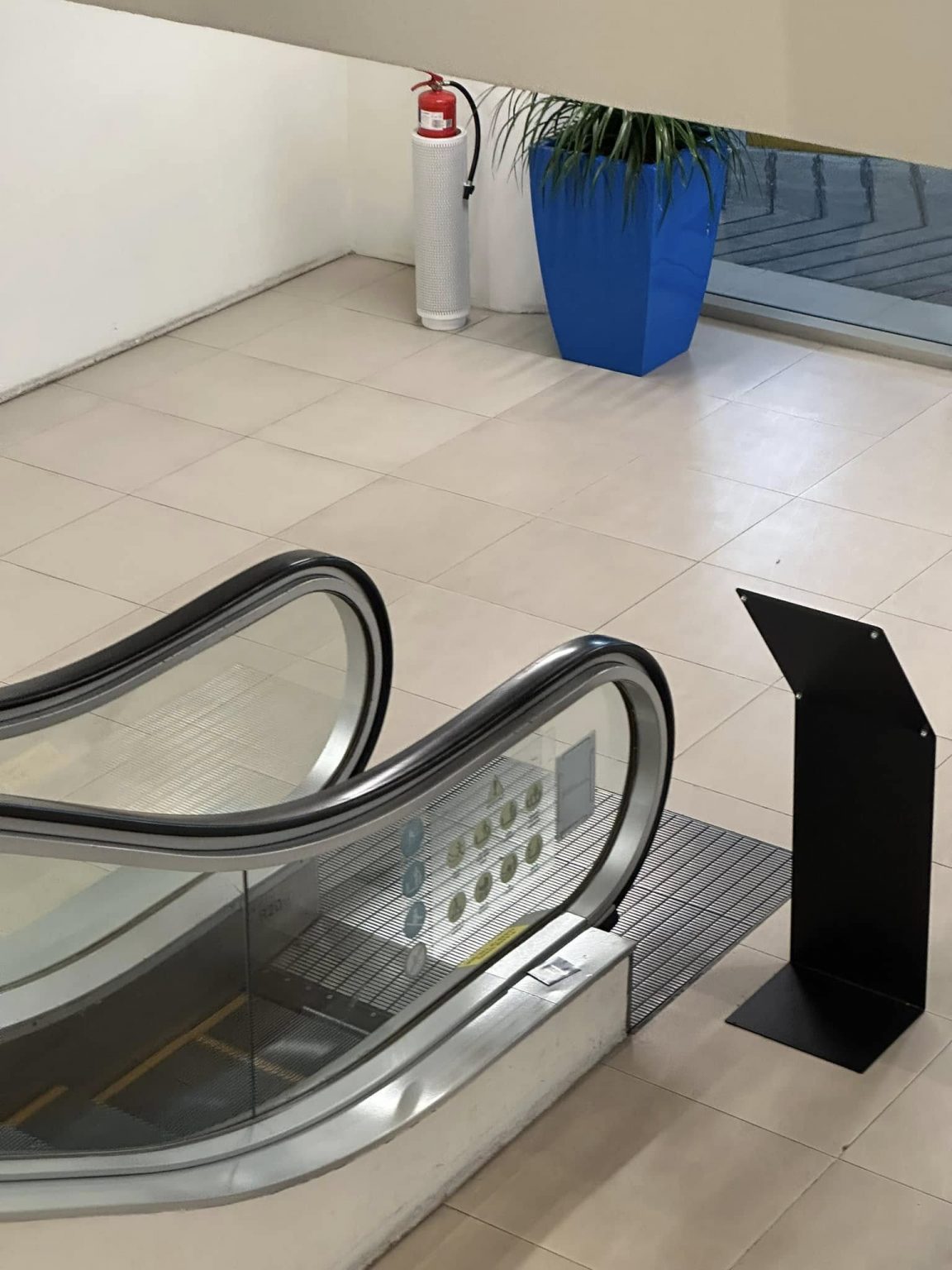 Man lifts Marina Square escalator landing with bollards to show safety ...