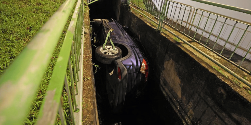 Car overturns into drain outside Clementi Police HQ after colliding ...